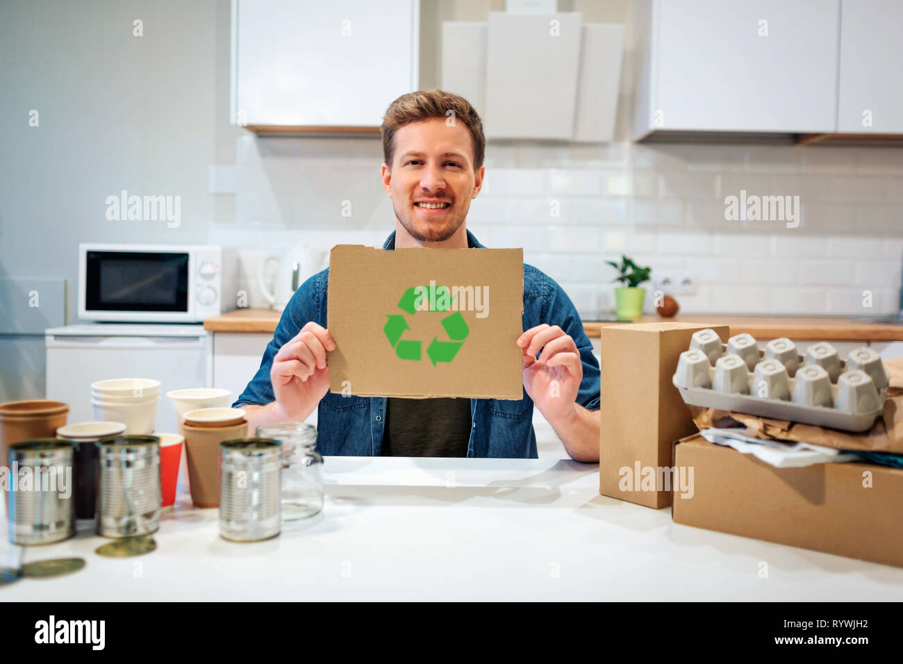 Recycle symbol. Young smiling man holding cardboard with recycle icon ...
