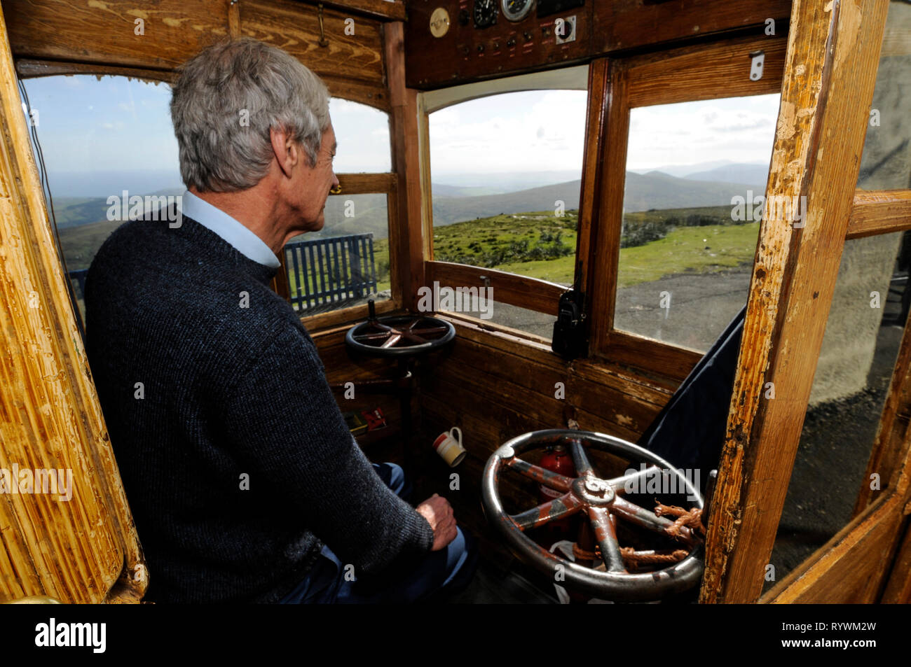 A tram driver in his cab at the controls of the 100 year old electric ...