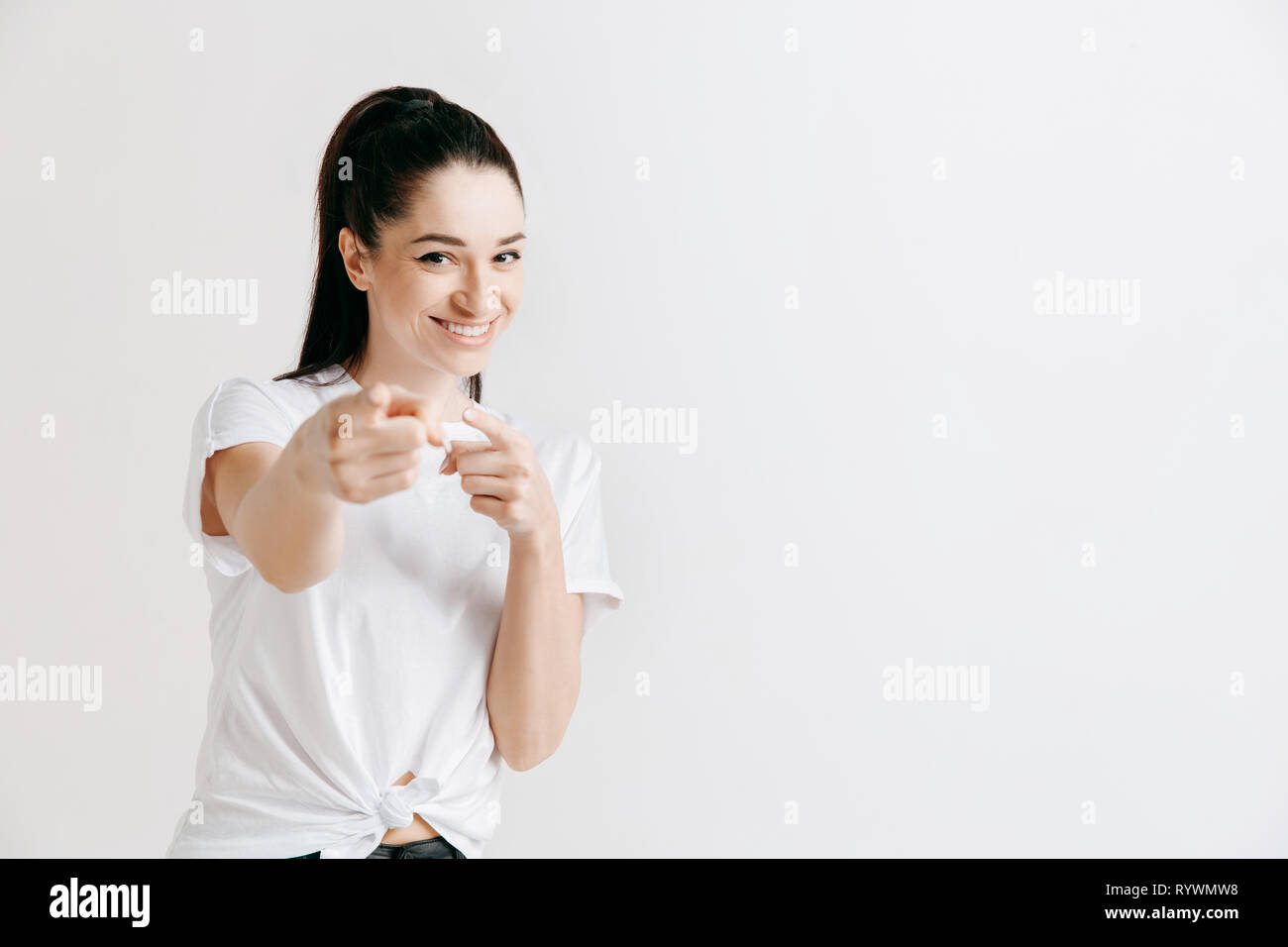 Happy woman standing and presenting something isolated on gray studio ...