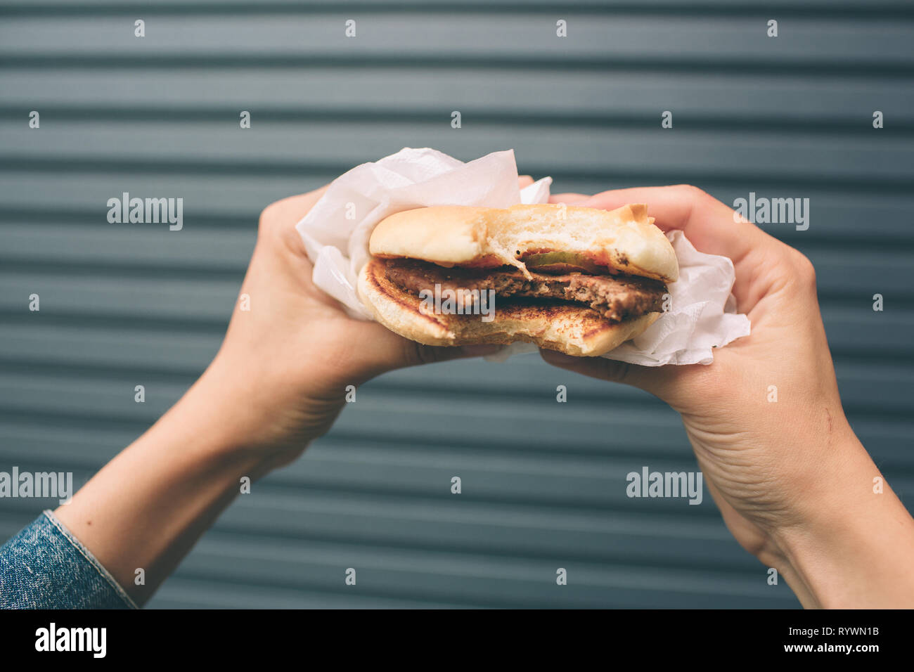 Eating hamburger. Delicious hamburger in the hands. Fastfood meal Stock ...