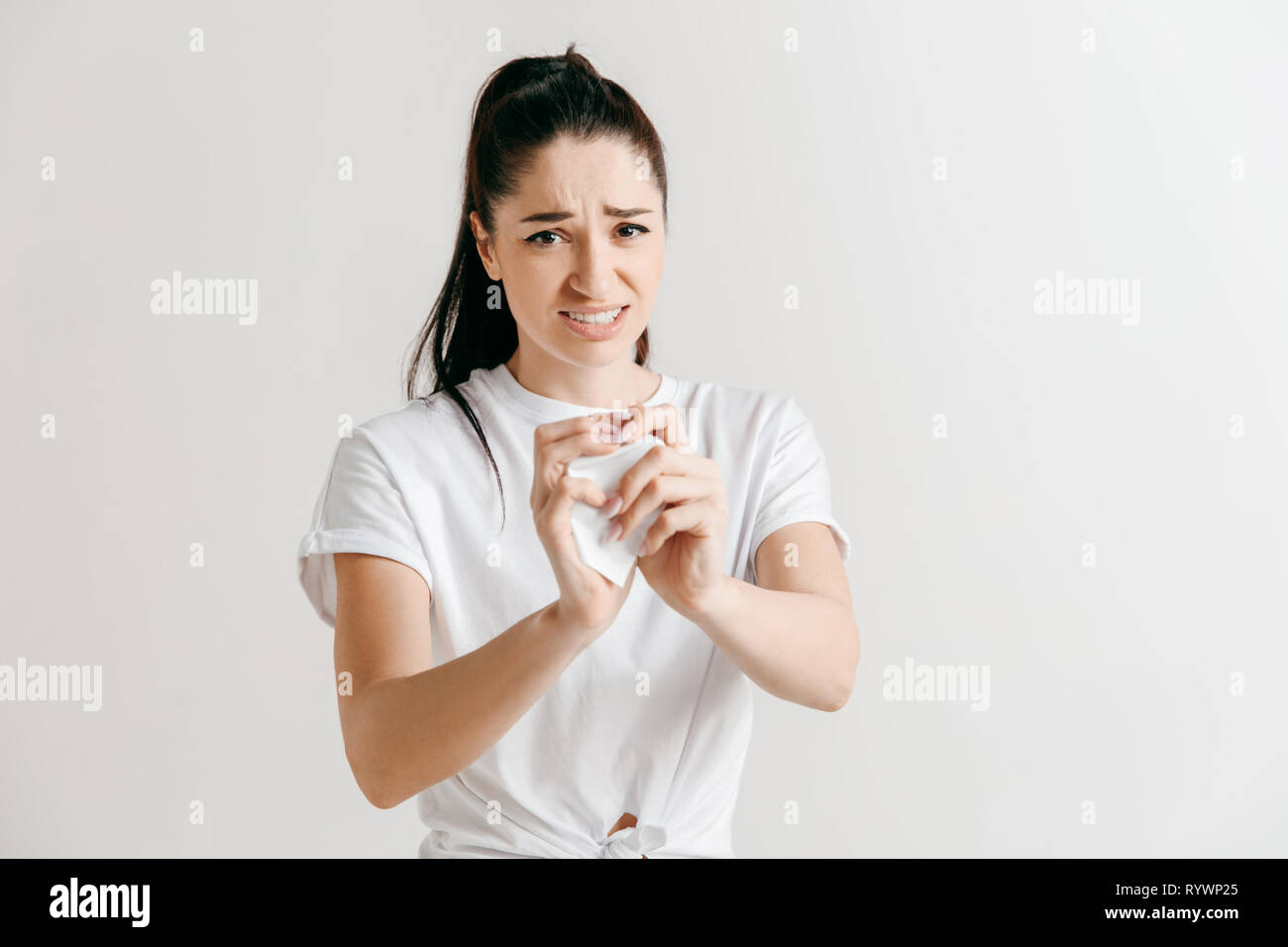 Young woman with a surprised unhappy expression lost a bet on studio ...