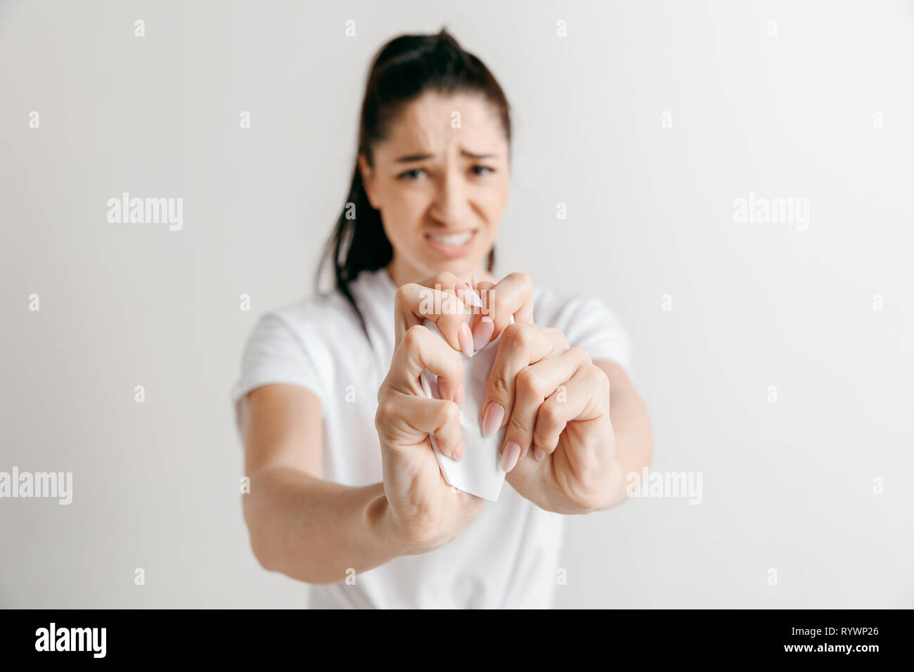 Young woman with a surprised unhappy expression lost a bet on studio ...