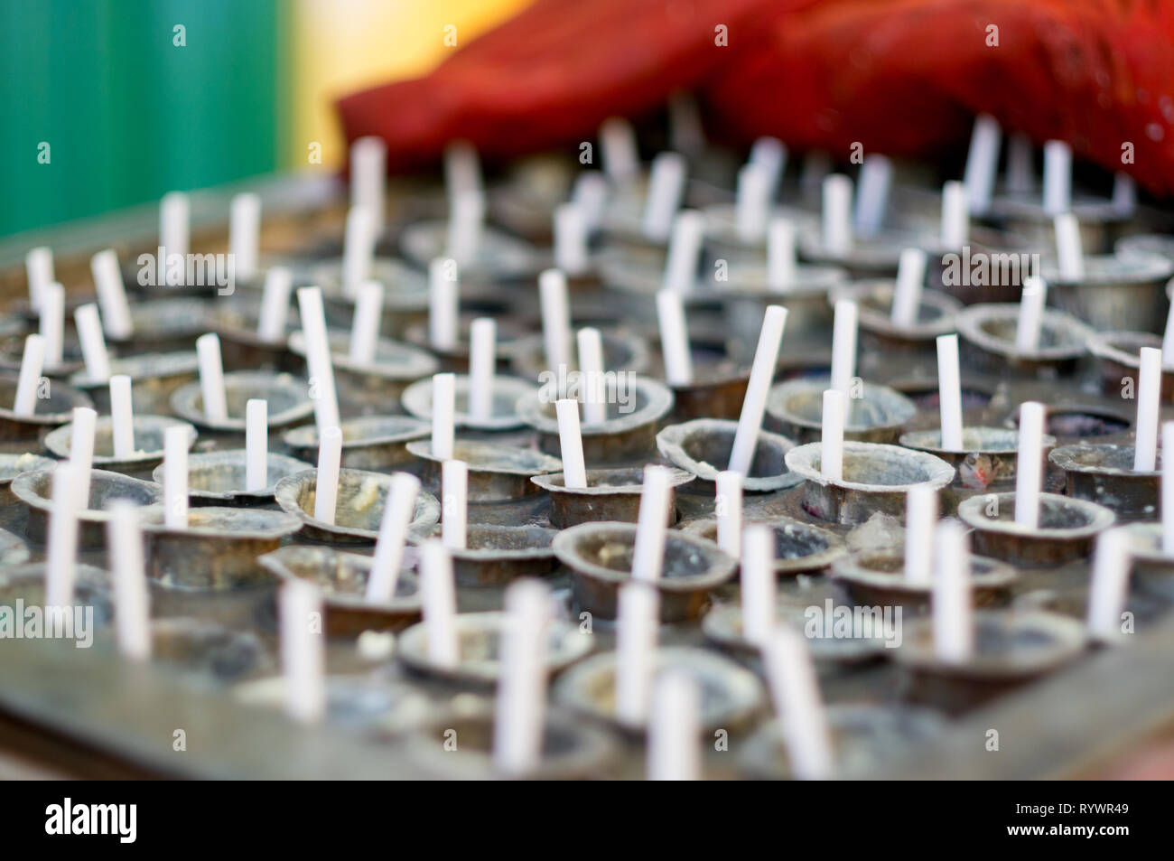 Traditional kulfi ice cream being frozen in steel molds in salt ice ...