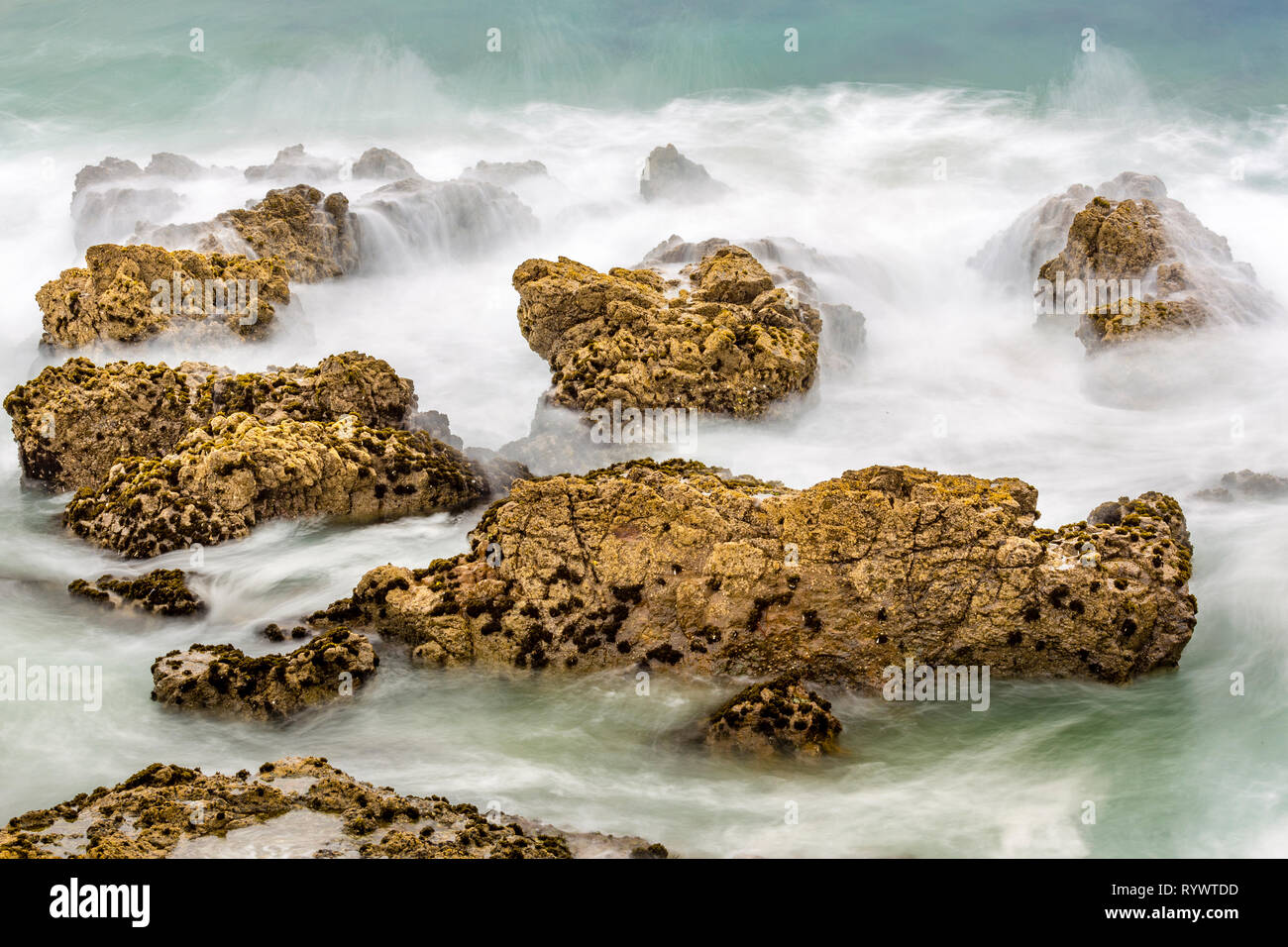 Gentle flowing water flowing around ocean rocks, Pacific ocean ...