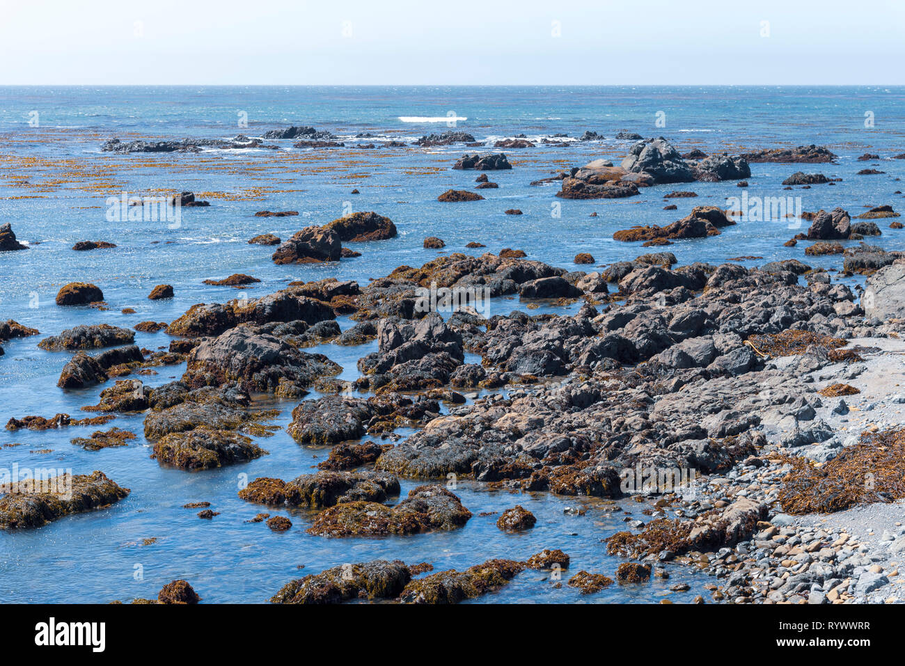 Blue ocean waves and rocky shore creating small tide pools Stock Photo ...