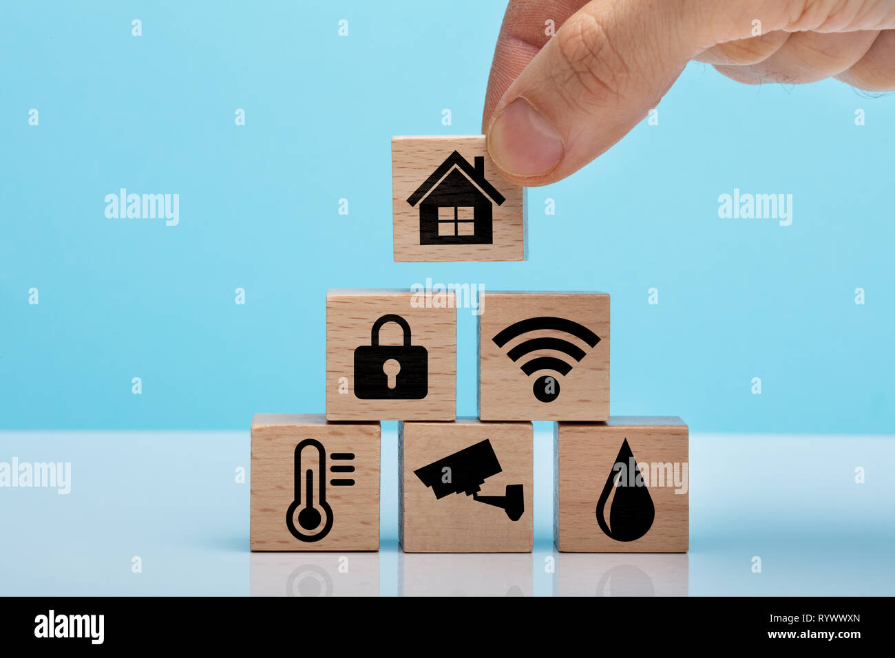 Hand Placing Wooden Block With Home Icon Over Stacked Home Automation ...