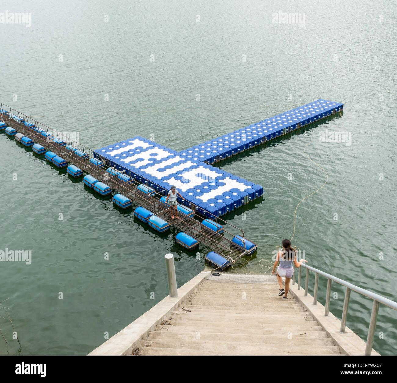 Teenager walking down stairs and mother standing on float at resevoir ...