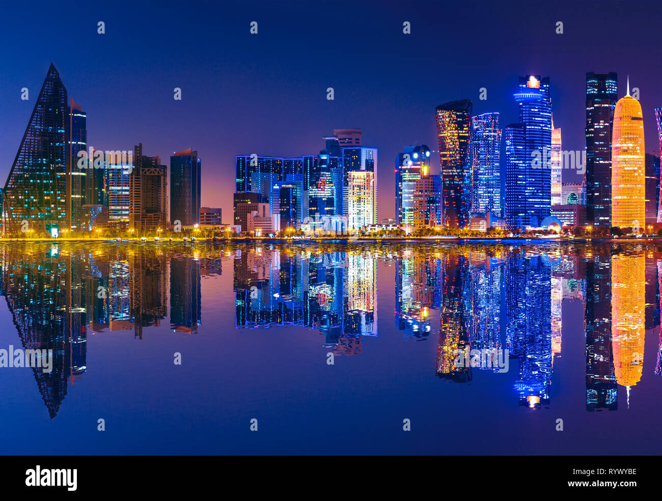 Doha West Bay skyline lighting by night reflecting in Doha Bay. Modern ...
