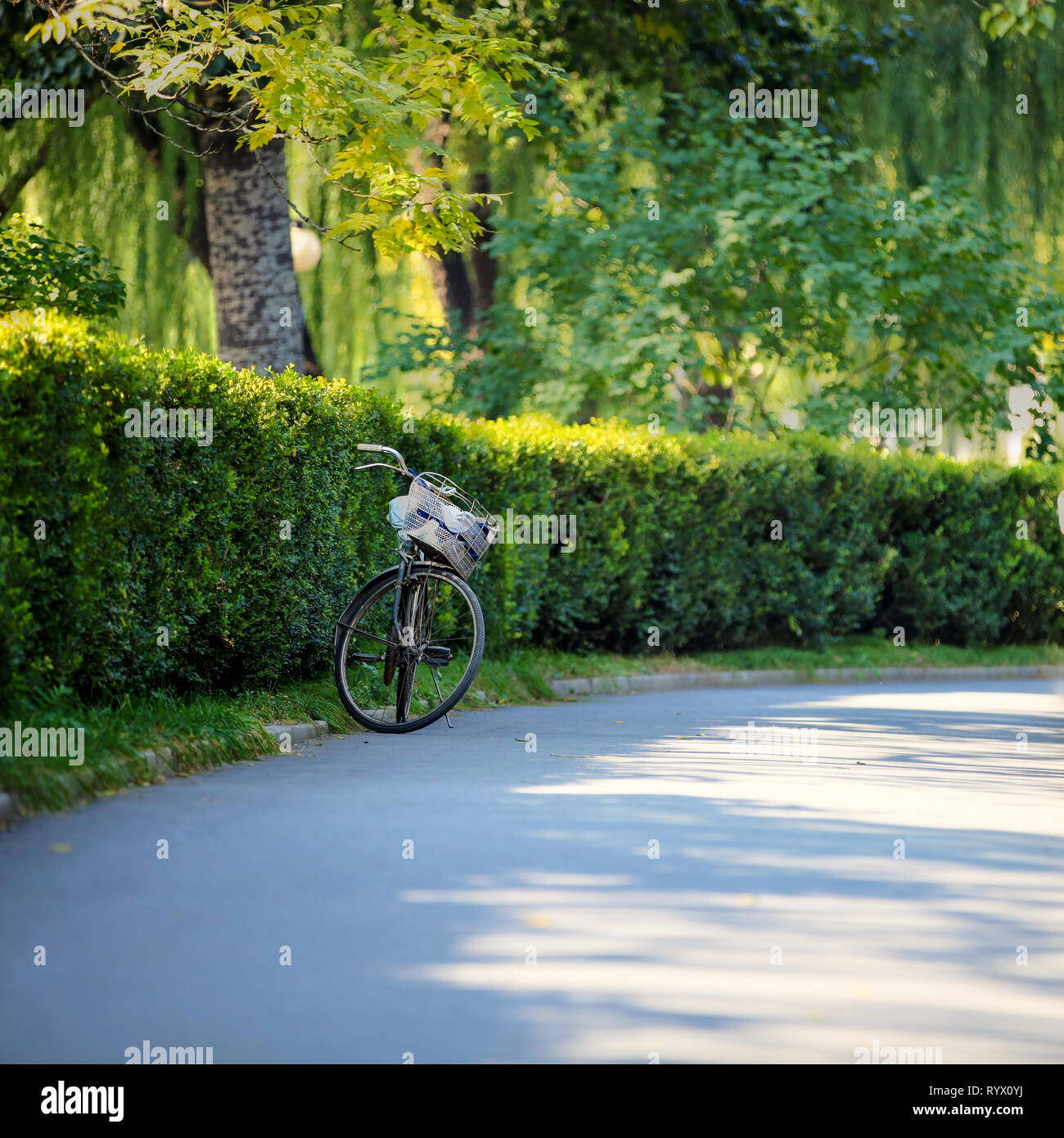 A bike is parked on the side of a clean paved path in Beijing China ...