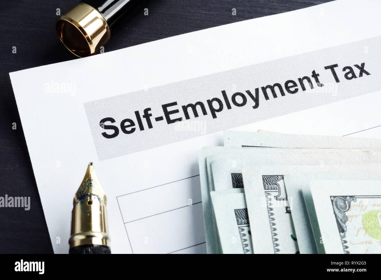 Self employment tax form and money with calculator Stock Photo - Alamy