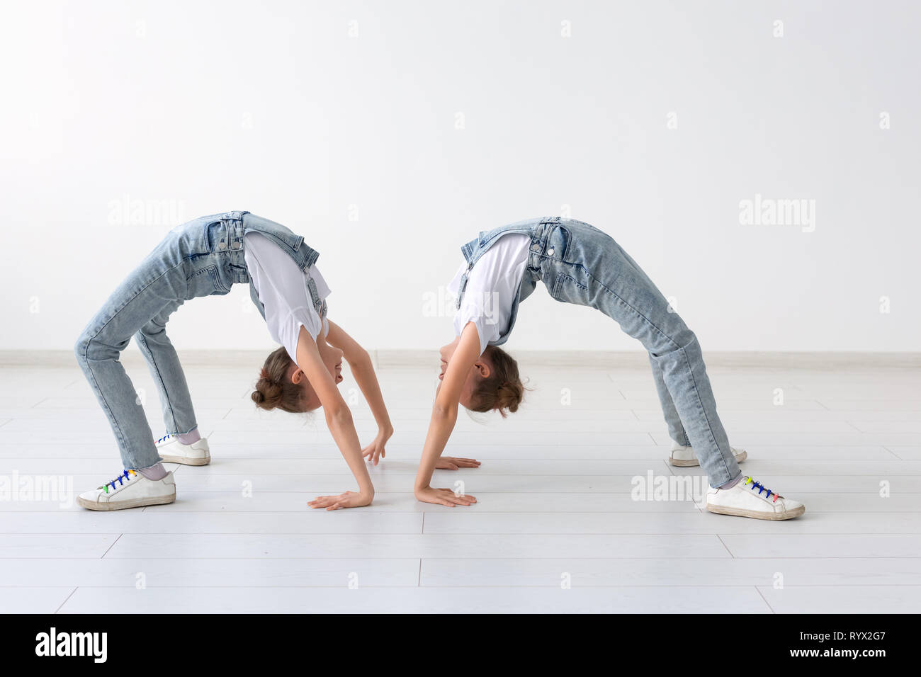 people, children and acrobatic concept - little twin sisters doing ...