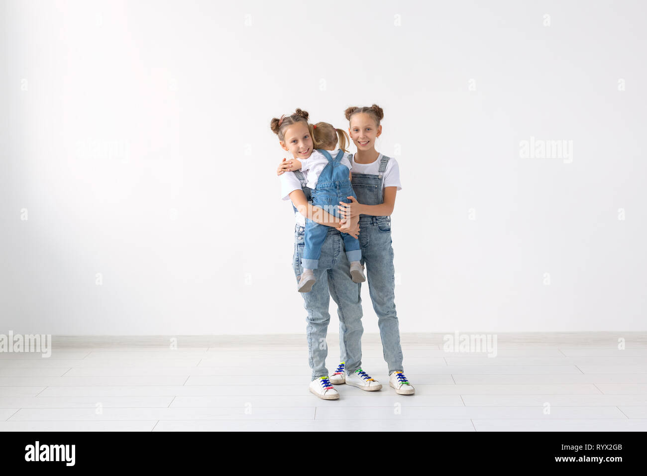 Family and love concept - Three sisters hugging over white background ...