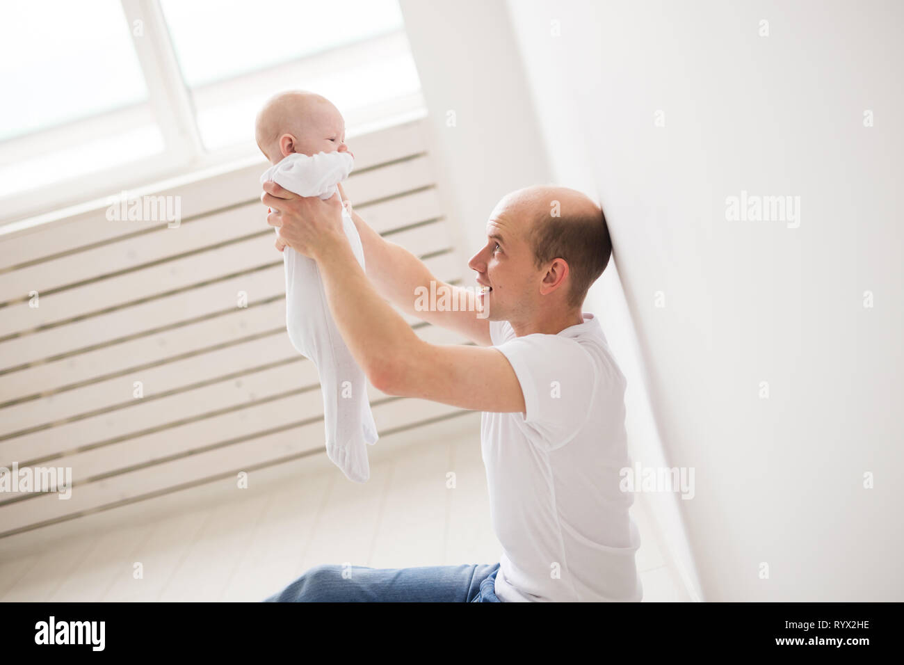 Parenting, family and fatherhood concept - Bald father sitting on the ...