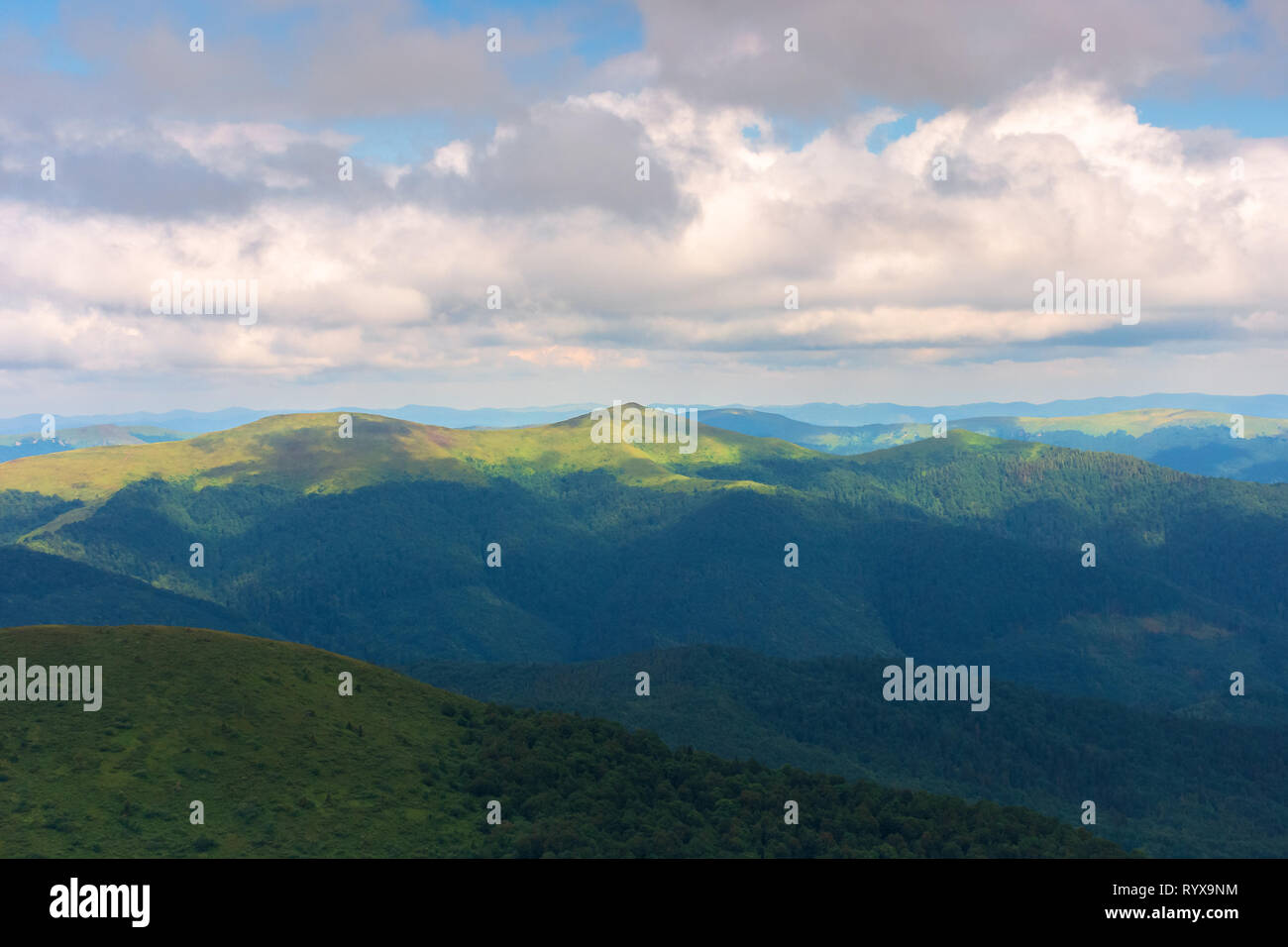 mountain landscape with cloudy sky. peaks of distant ridge in sunlight ...