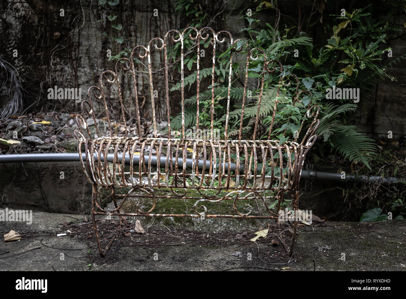 An old rusty, once white, metal bench that has seen its best days Stock ...