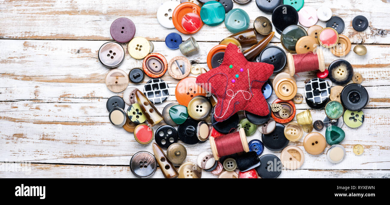 Spools of threads and buttons on wooden table.Scissor, sewing buttons ...