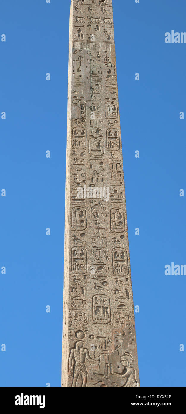 Ancient Egyptian obelisk with hieroglyphics and blue sky background ...