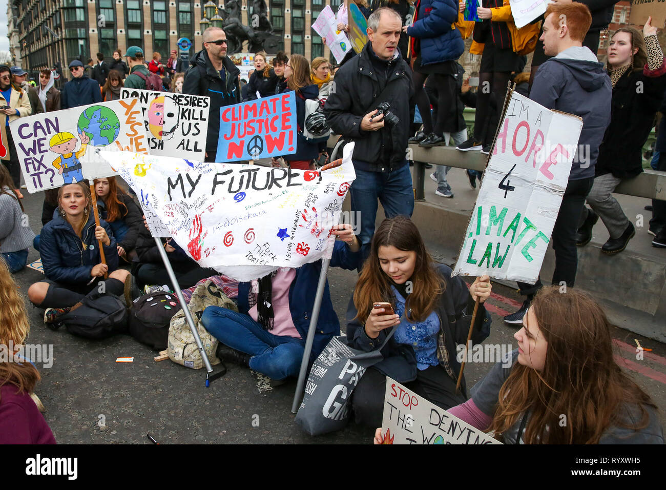 Students are seen holding placards seating on the ground and blocking ...