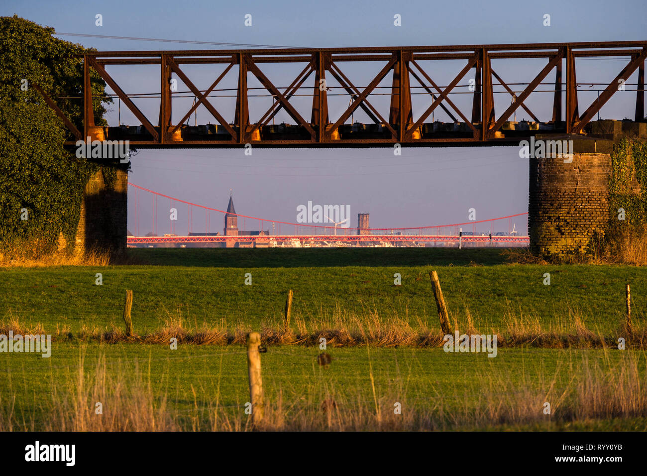 Abandoned railway bridge in north german countryside with small city in ...
