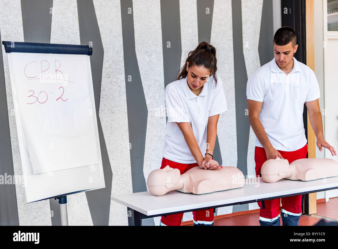 CPR class with instructors talking and demonstrating first aid ...