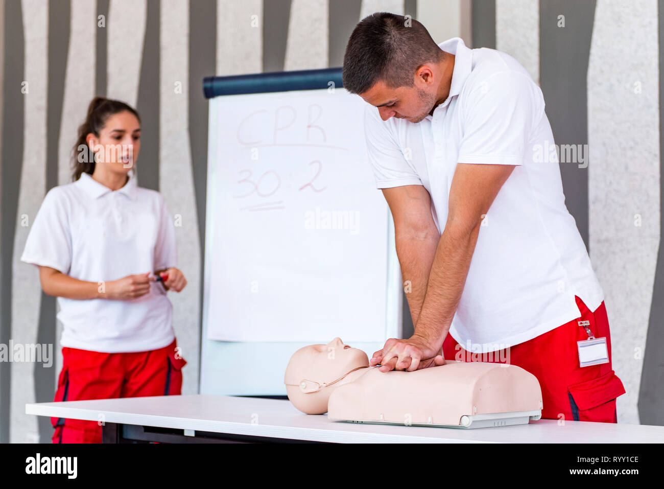 CPR class with instructors talking and demonstrating first aid ...
