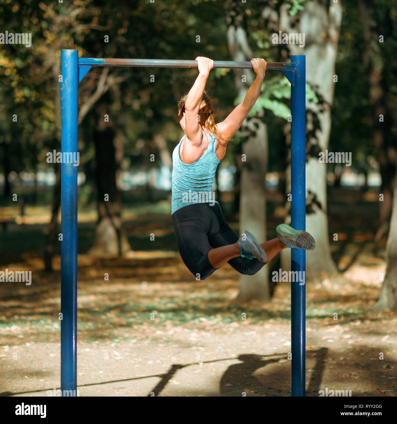 MODEL RELEASED. Woman exercising on outdoor horizontal bar Stock Photo ...
