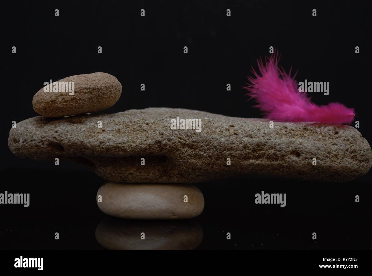 feather red and stone balance Stock Photo - Alamy
