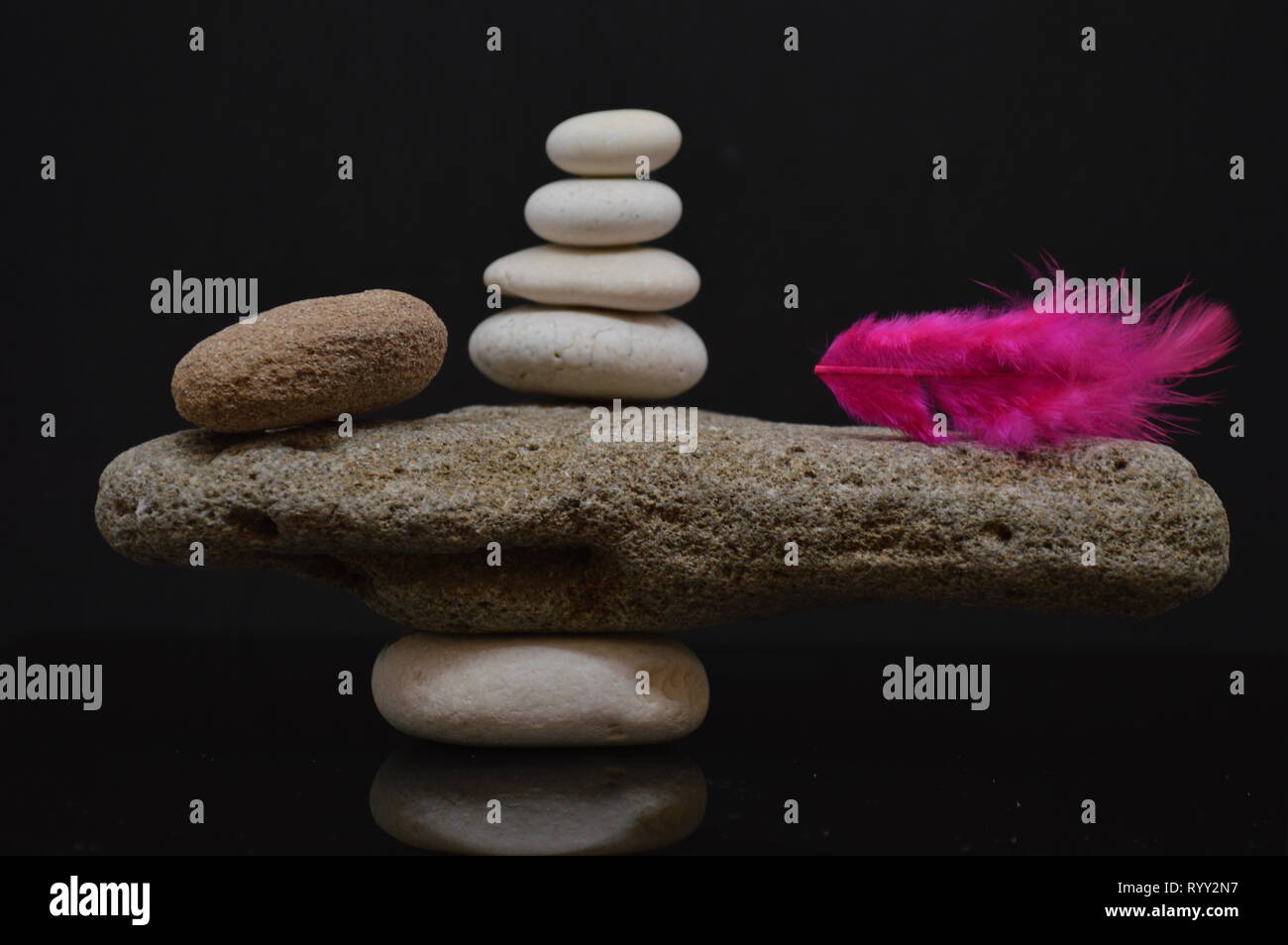 feather red and stone balance Stock Photo - Alamy