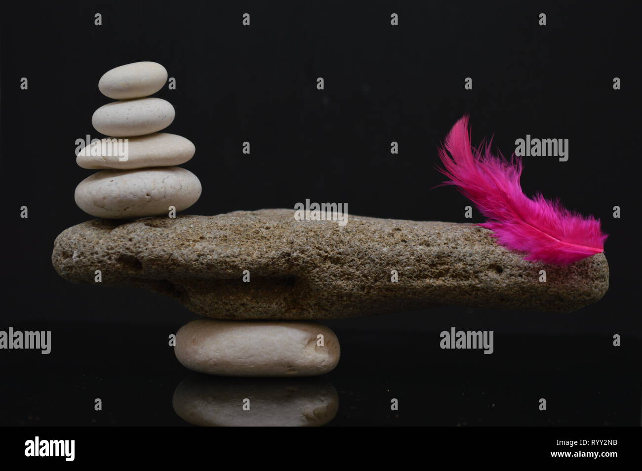 feather red and stone balance Stock Photo - Alamy