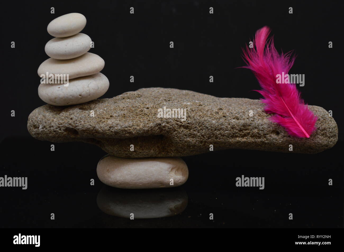 feather red and stone balance Stock Photo - Alamy