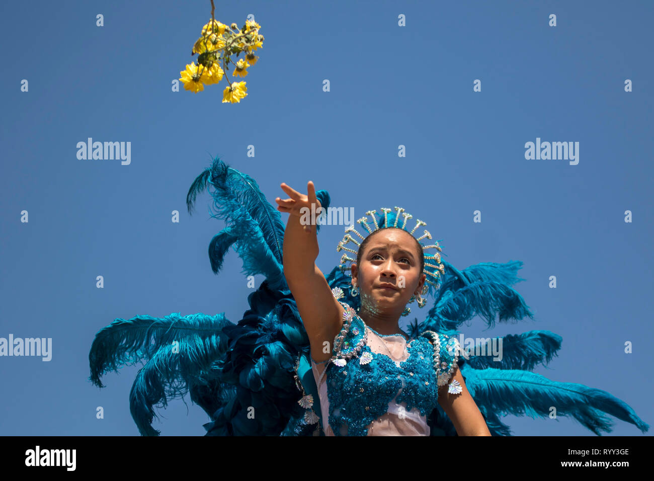 Little girl throwing flowers to the crowd. The battle of flowers is an ...