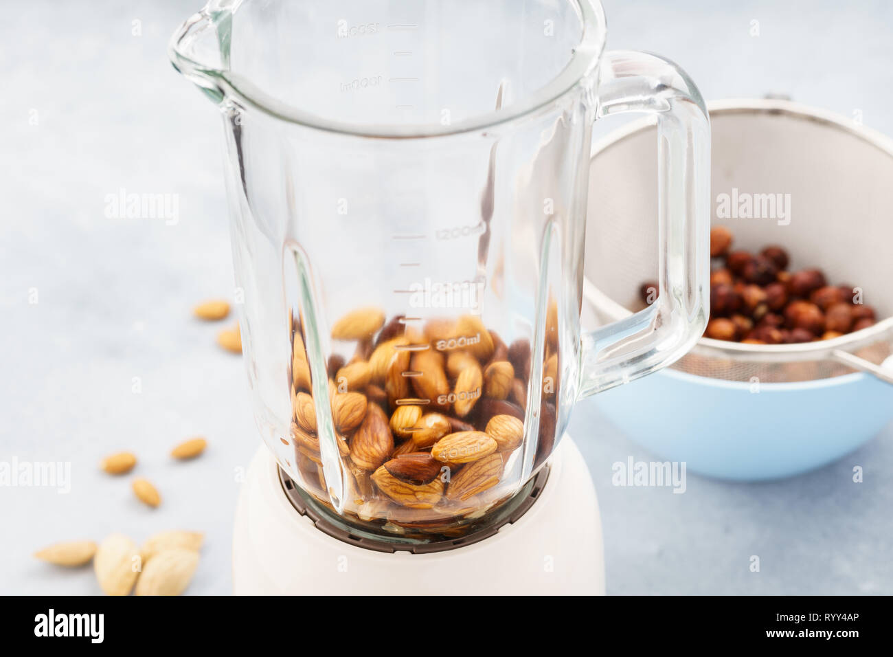 Blender and almonds soaked in water. Making healthy vegan milk Stock ...