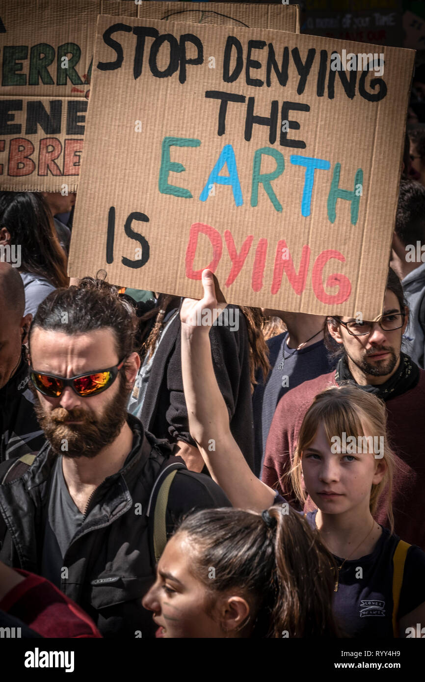 A demonstrator is seen holding a placard saying stop denying the earth ...