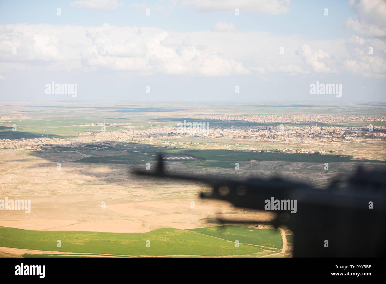 A Coalition Forces member surveils the landscape while manning an M240H ...