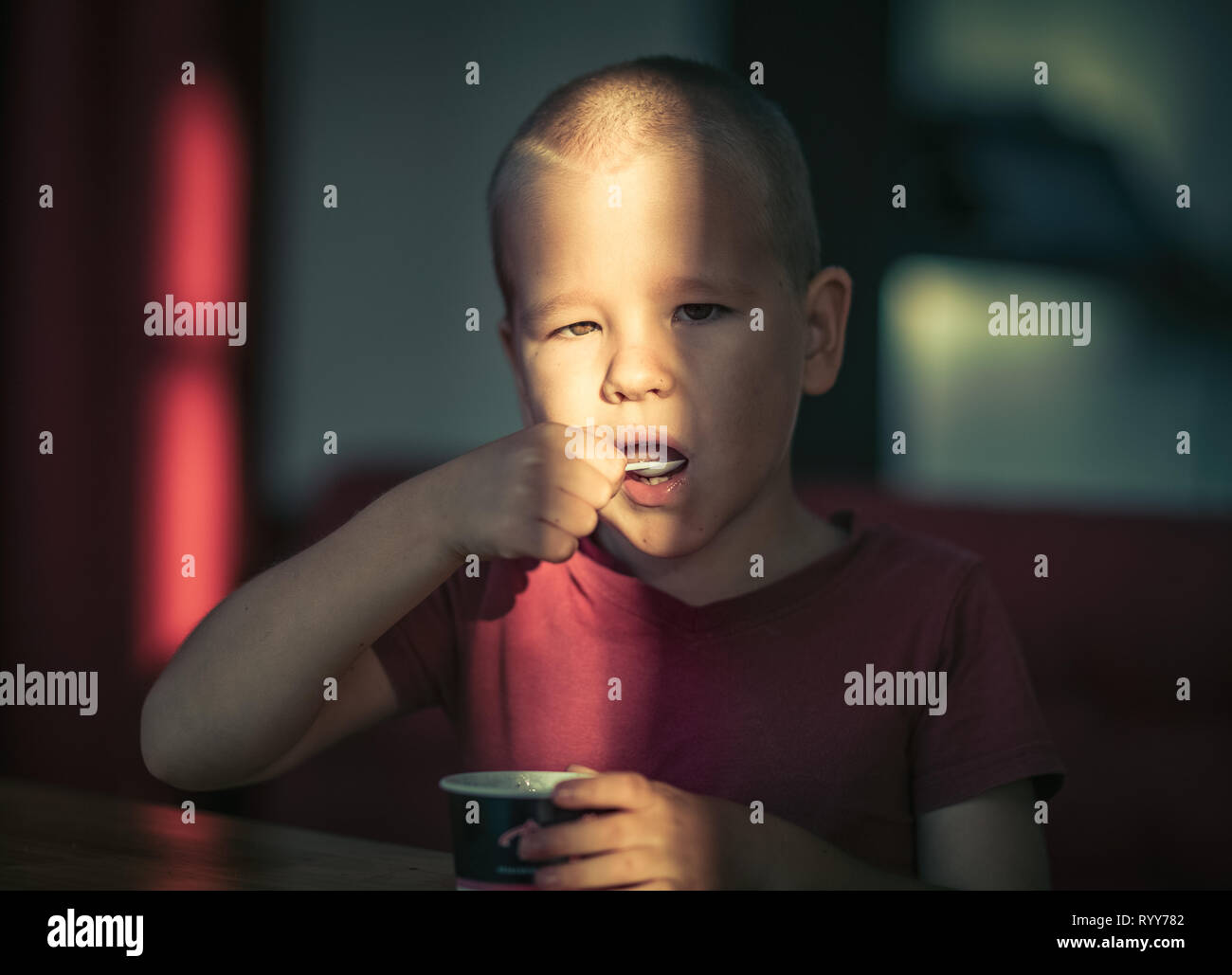 Portrait of a smiling boy eating ice cream. High contrast hard light ...