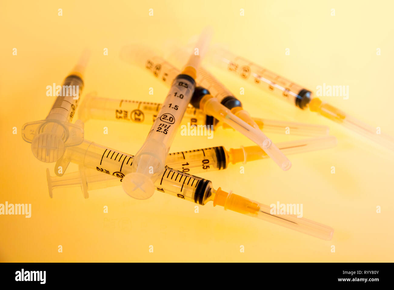 Group of syringes on orange background Stock Photo - Alamy