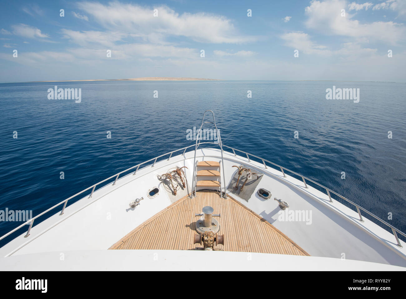 View over the bow of a large luxury motor yacht on tropical open ocean ...