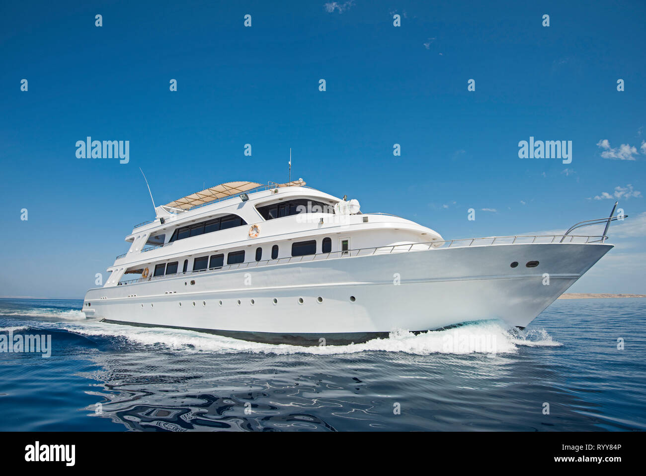 Large luxury motor yacht under way sailing out on tropical sea ocean ...