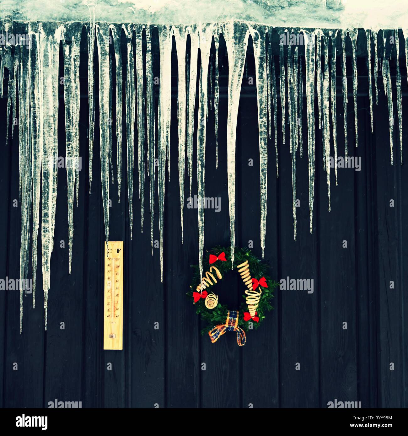 Beautiful icicles hanging from the house roof in winter. Concept for ...