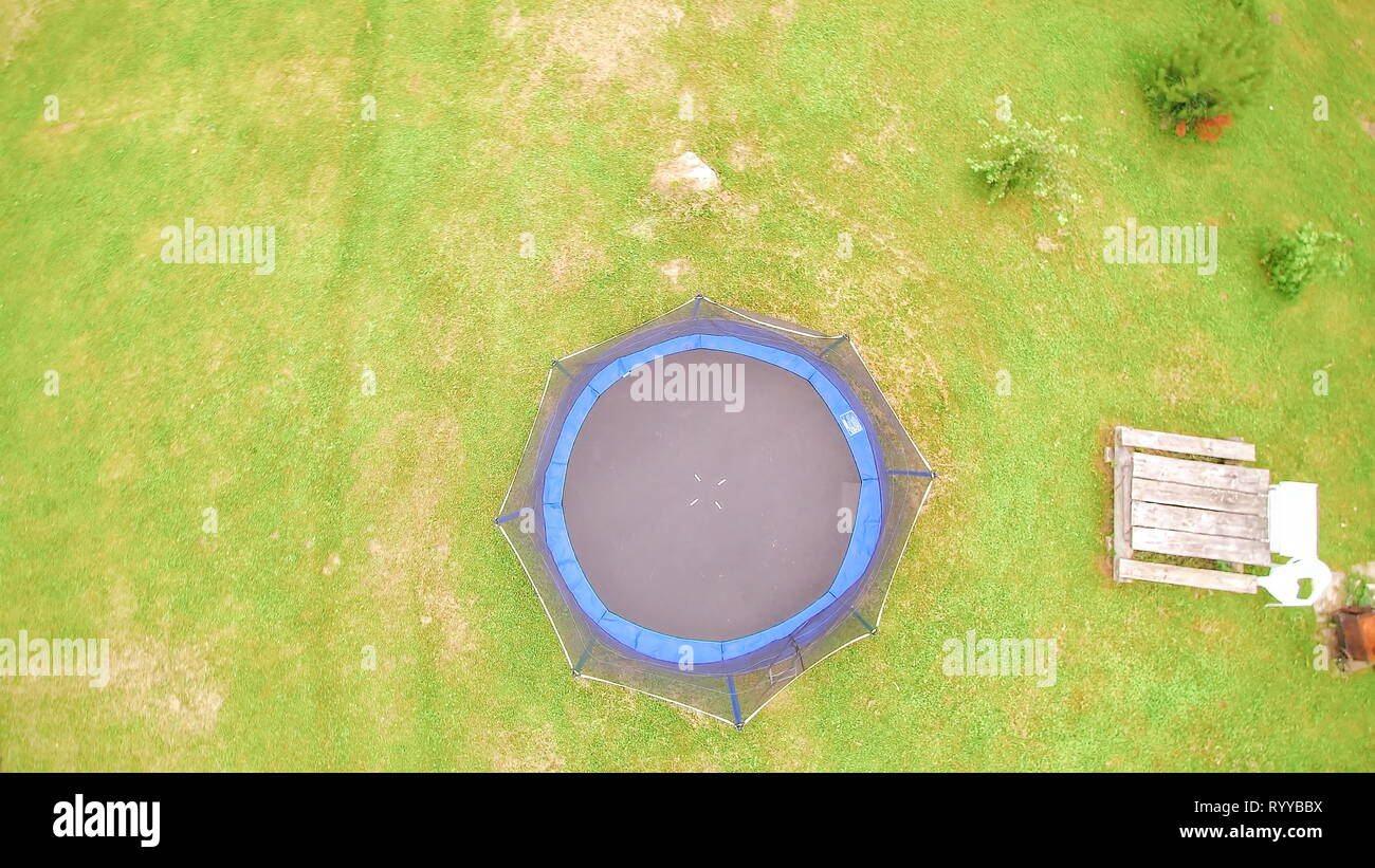 Aerial shot of the trampoline on the playground it is a big round area ...