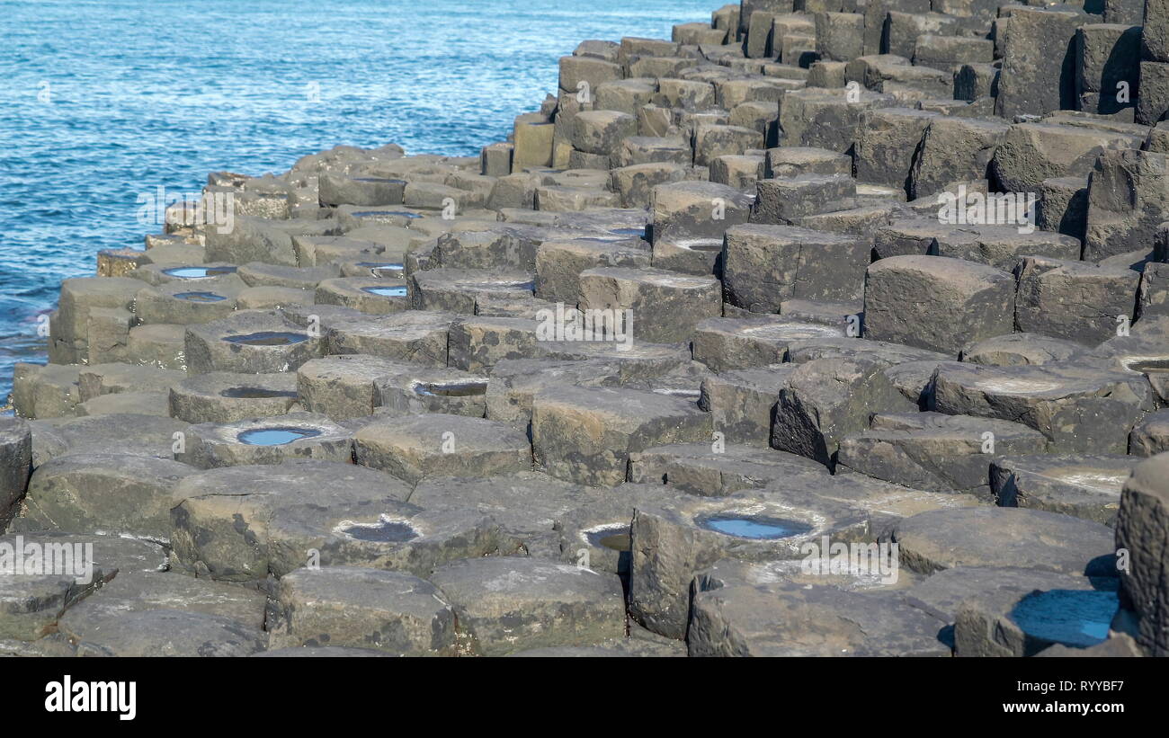 Small square rocks in the sea in Giants Causeway forming the mountain ...