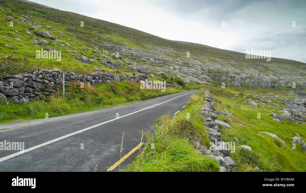 The rocks on the mountain in Ireland coast with the small road going up ...