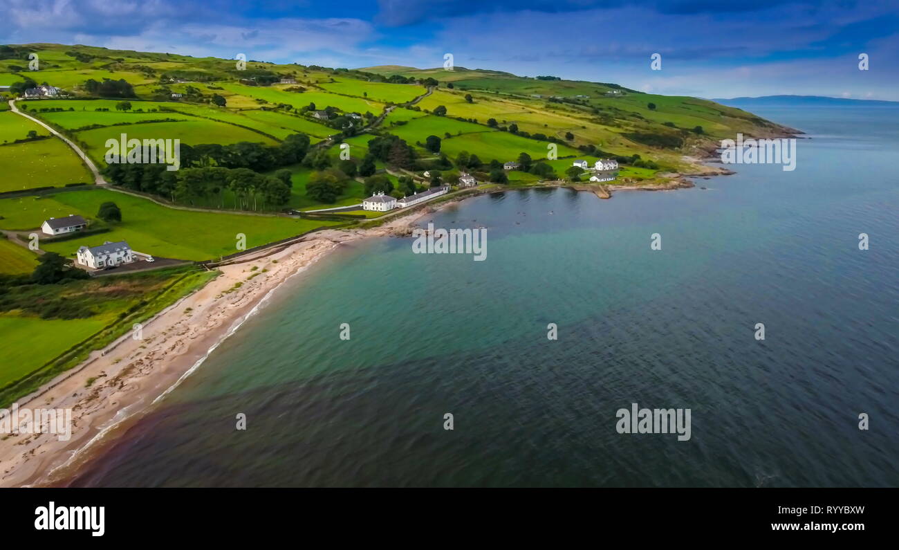 Aerial shot of the coastal area in Cushendun where there are houses on ...