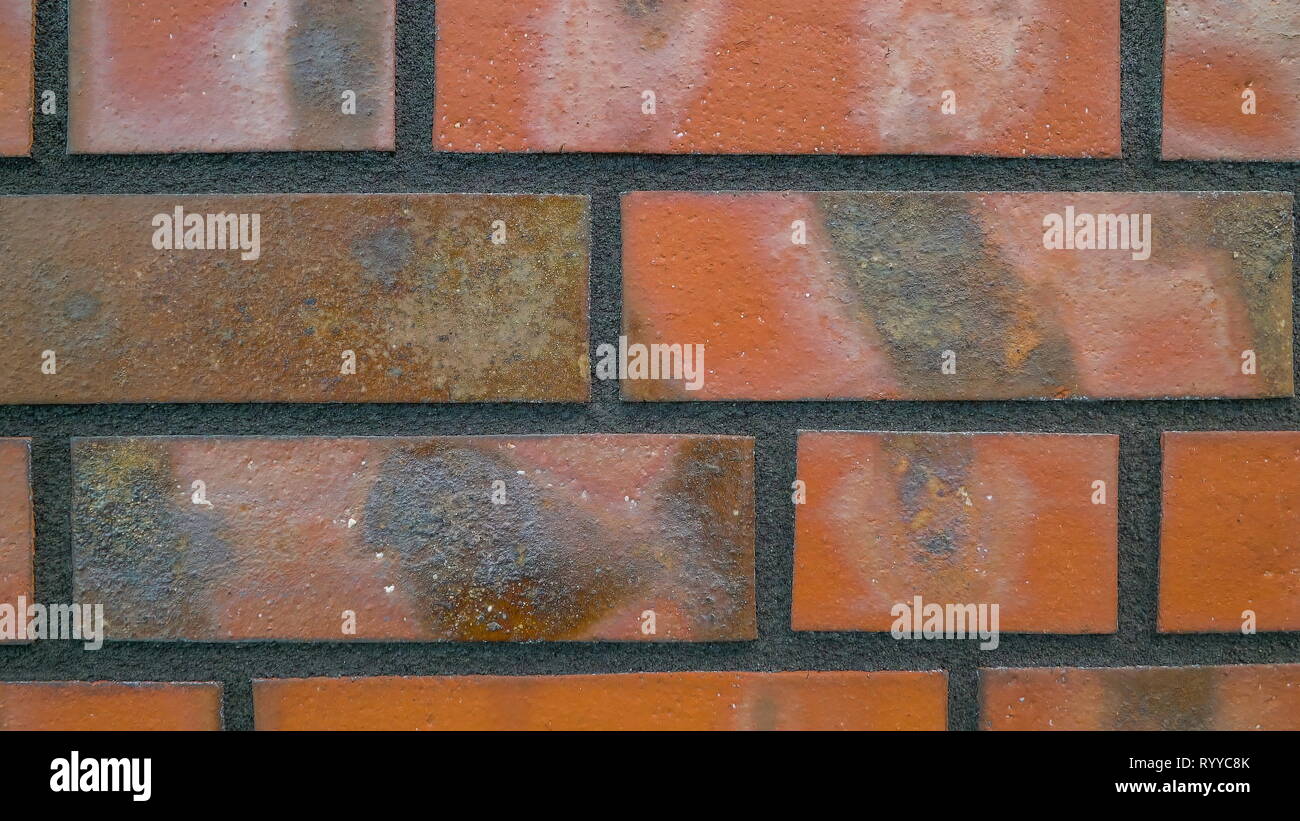A wall with the red bricks and black cement or outline that puts the ...