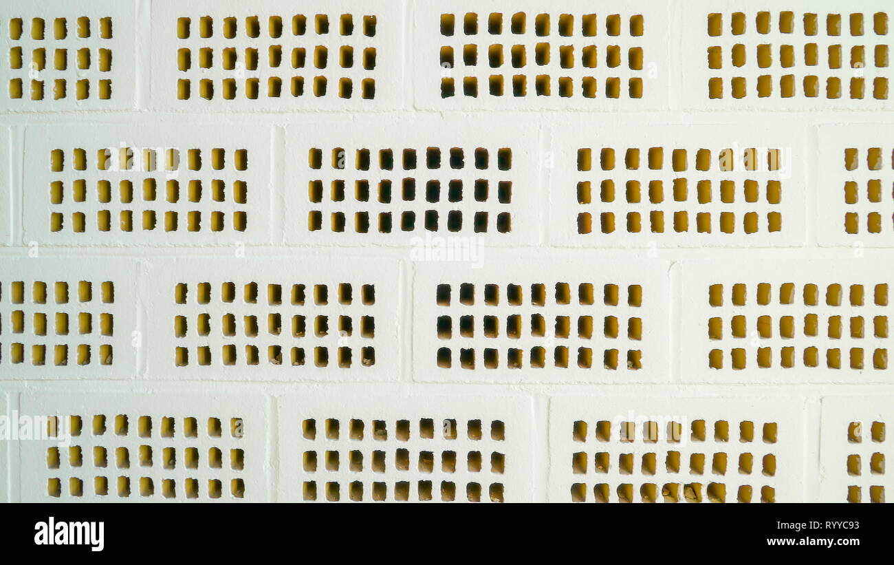 The white brick wall with small square holes one of the display of ...