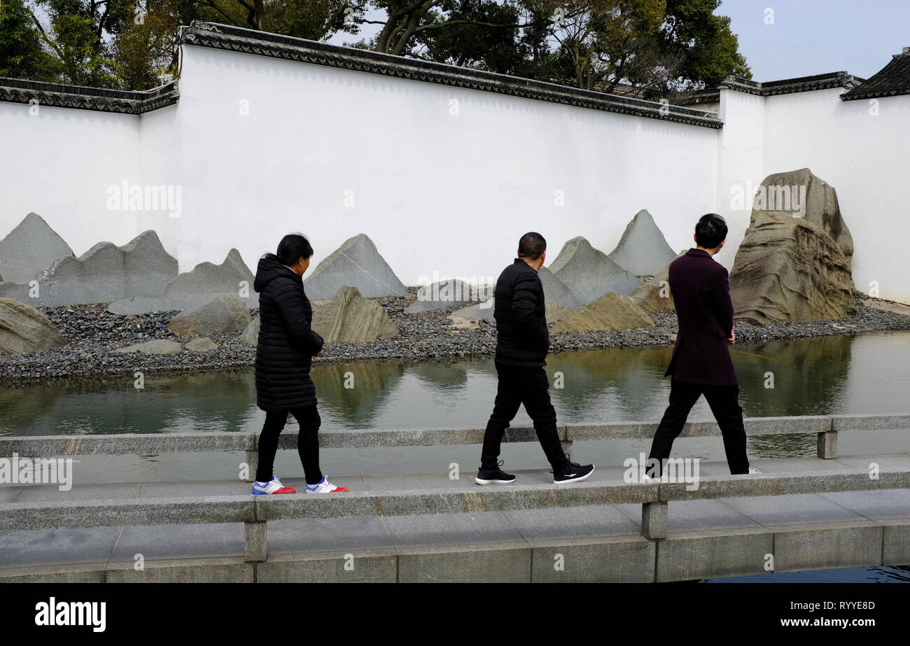 Red fishes in the reflecting pool with rockery by the wall in the ...
