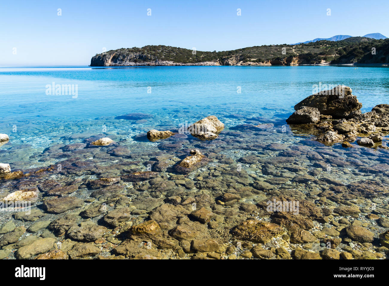 Beautiful crystal clear turquoise waters coast with small pebble stones ...