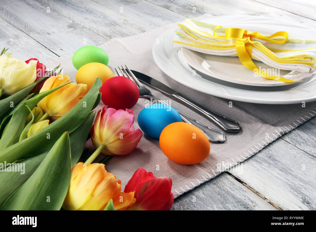 Festive table setting for Easter with fork, knife and tulip on spring ...