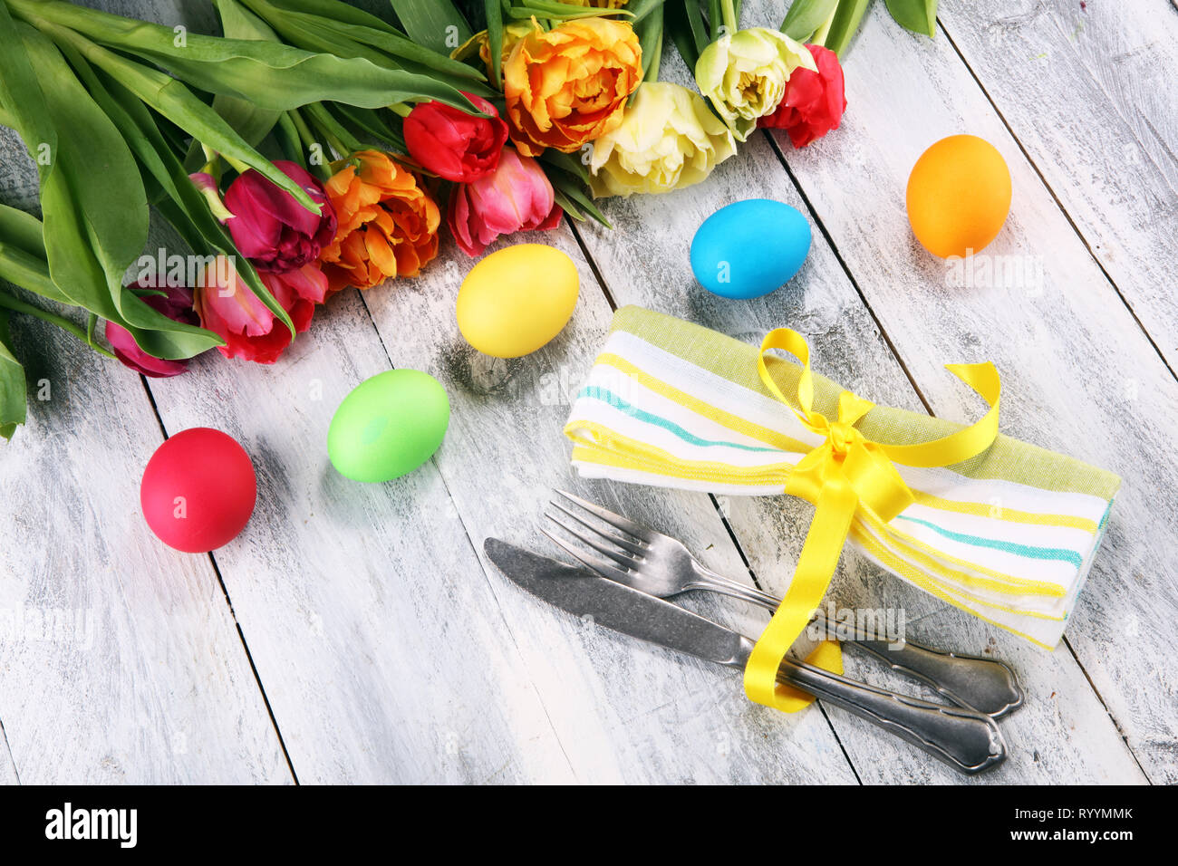 Festive table setting for Easter with fork, knife and tulip on spring ...