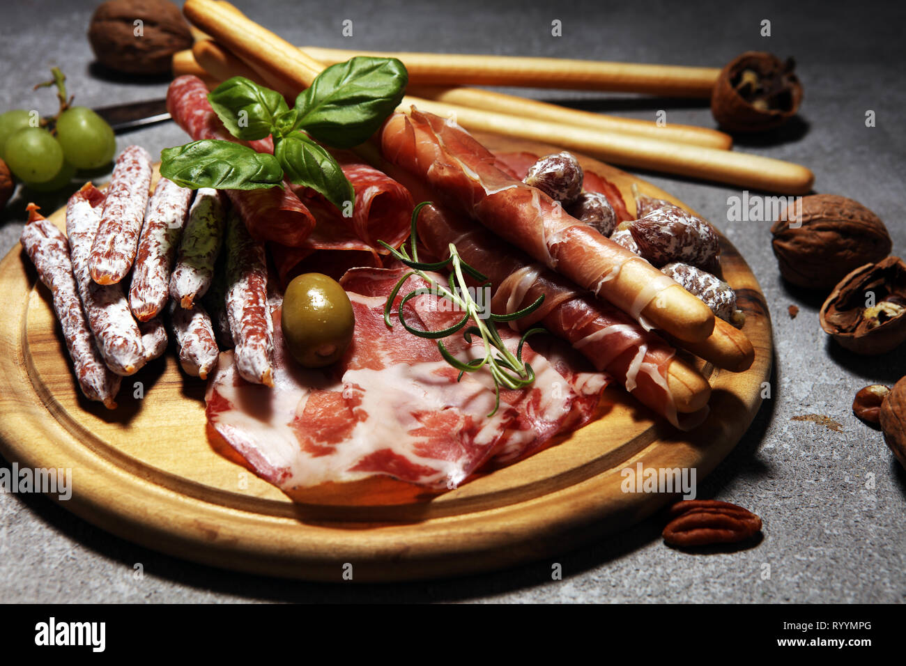 Food tray with delicious salami, coppa, fresh sausages and herbs. Meat ...